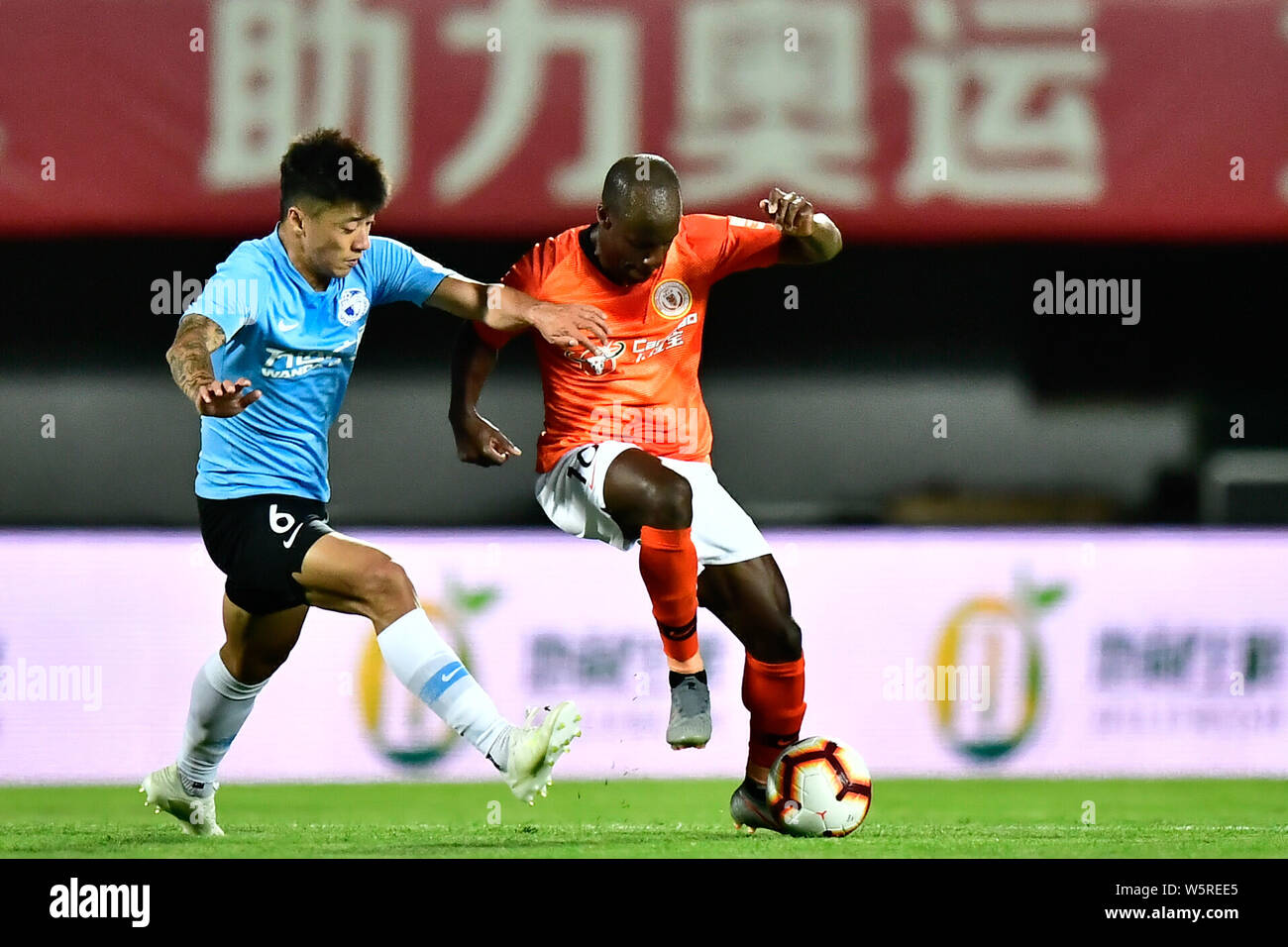 Fußballspieler Sone Aluko, rechts, von Peking Renhe passt den Ball ...