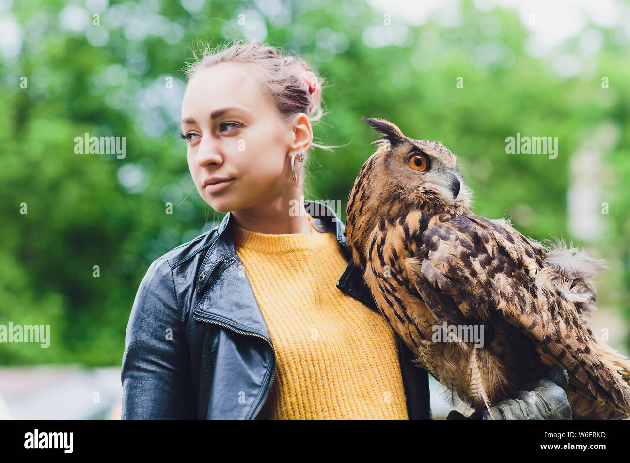 Die Eule sitzt auf der Hand des Mädchens. Die Frau mit der Eule ...