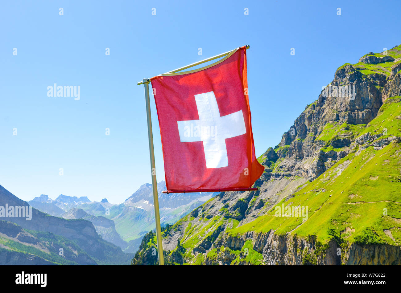 Wehende Flagge der Schweiz mit Sommer Berglandschaft im Hintergrund ...