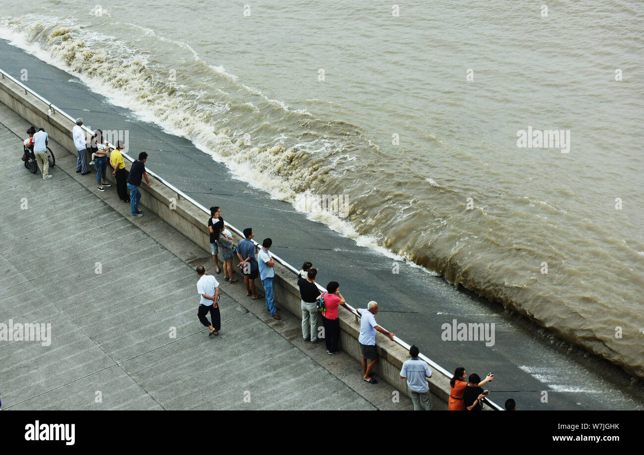 Besucher und Anwohner beobachten die Tidal Bore der Fluss Qiantang in ...