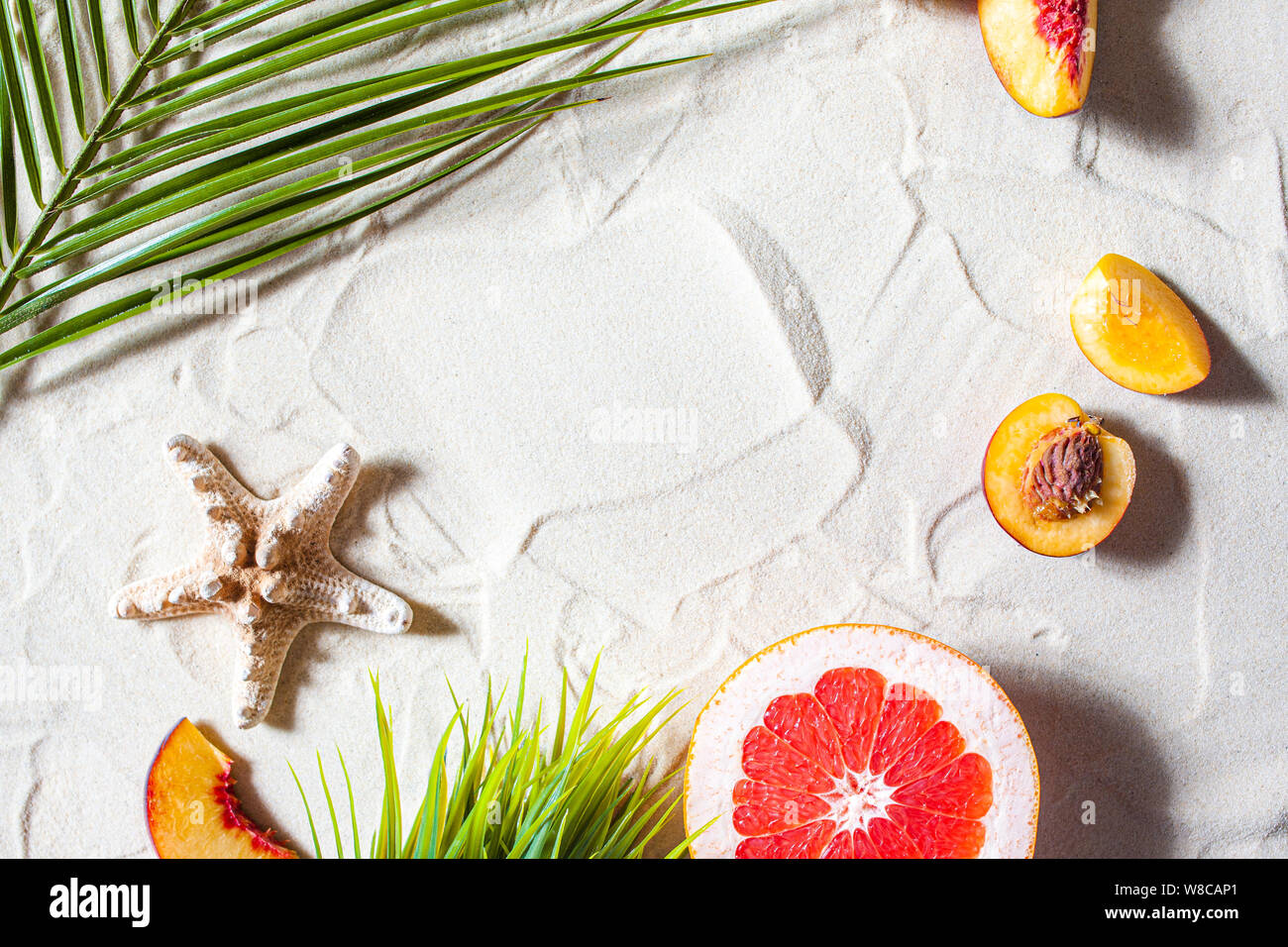 Bezaubernden Strand. Helle Früchte, ein Seestern, und Palm Blätter ...