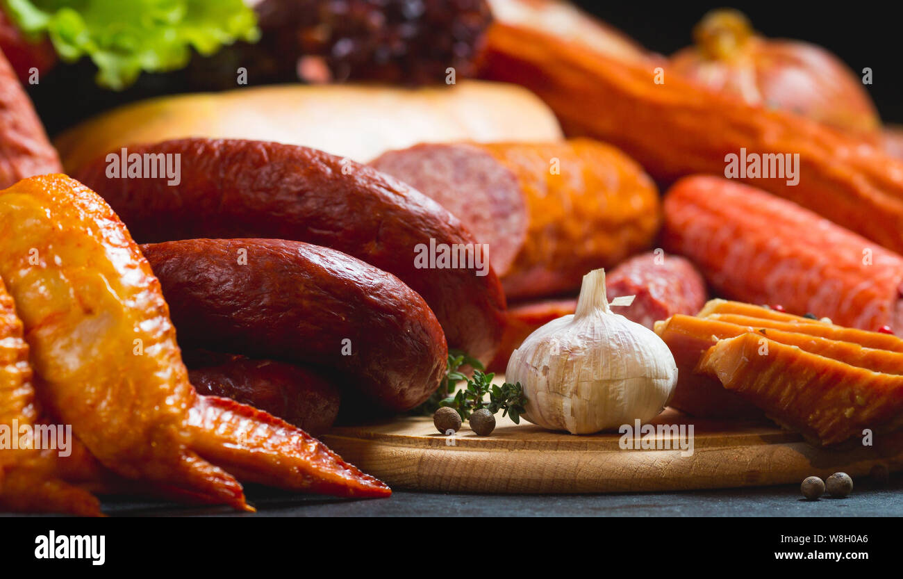 Verschiedene Arten von Wurst und Fleischerzeugnissen auf schwarzem ...