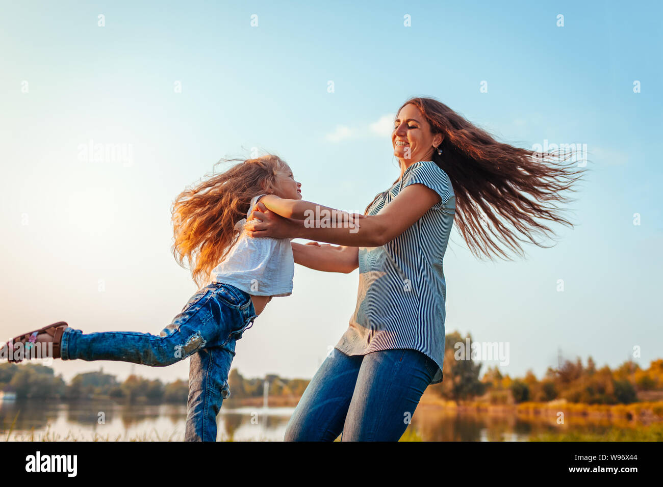 Familie spielen und Spaß haben bis zum Sommer River bei Sonnenuntergang ...