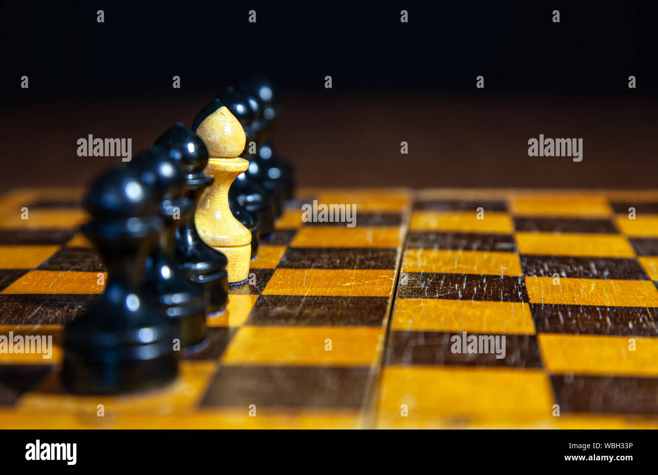 Eine weiße Schach schachfigur stehen in einer Reihe von schwarzen ...
