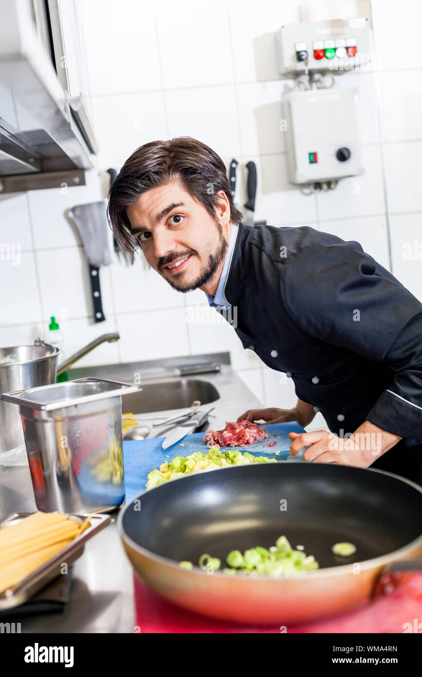 Profi-Koch in einer Großküche ein Gemüse unter Rühren braten über einem ...