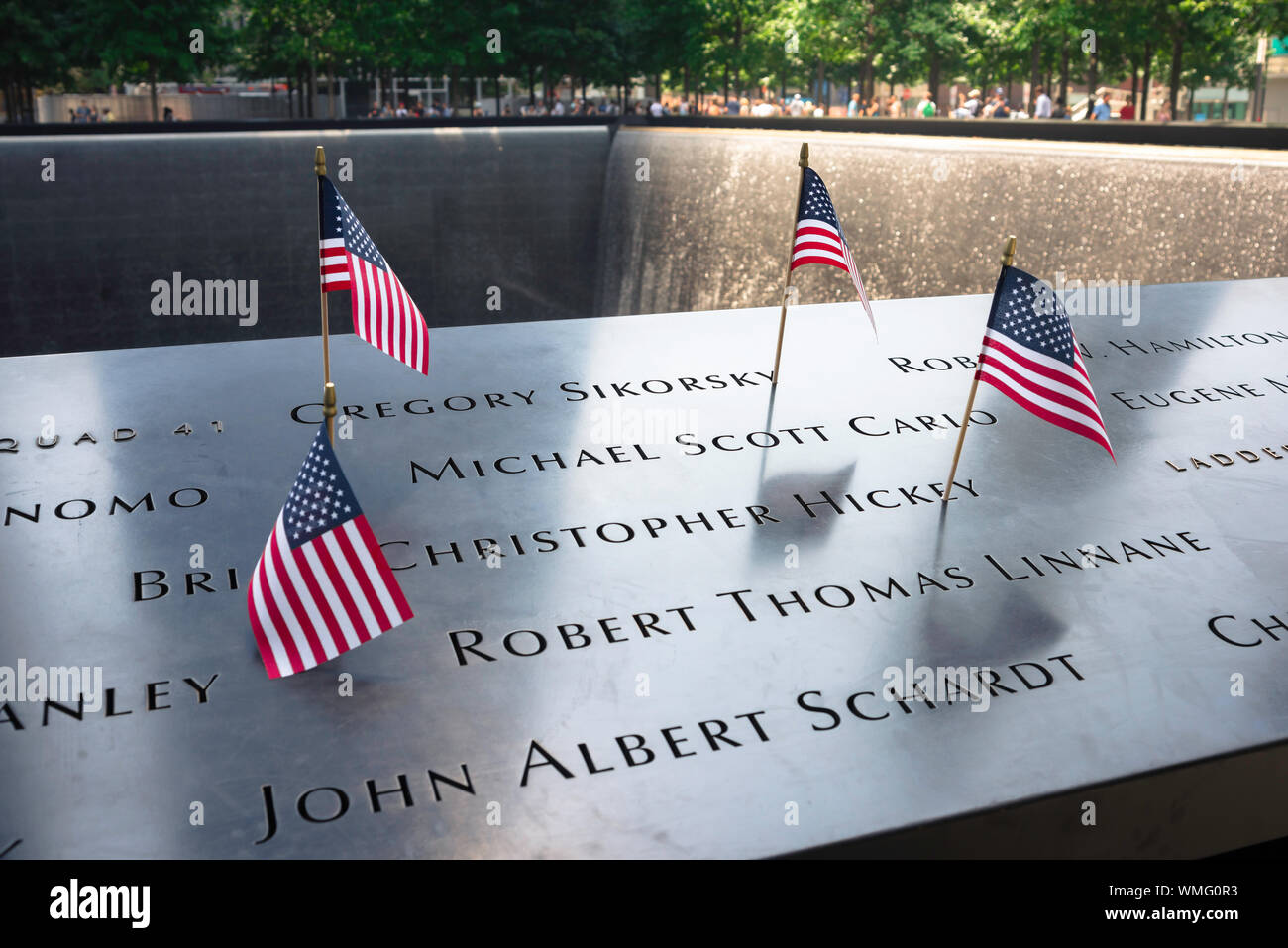 9/11 Memorial, USA Flaggen platziert auf einer Attika mit den Namen der Personen in den ...