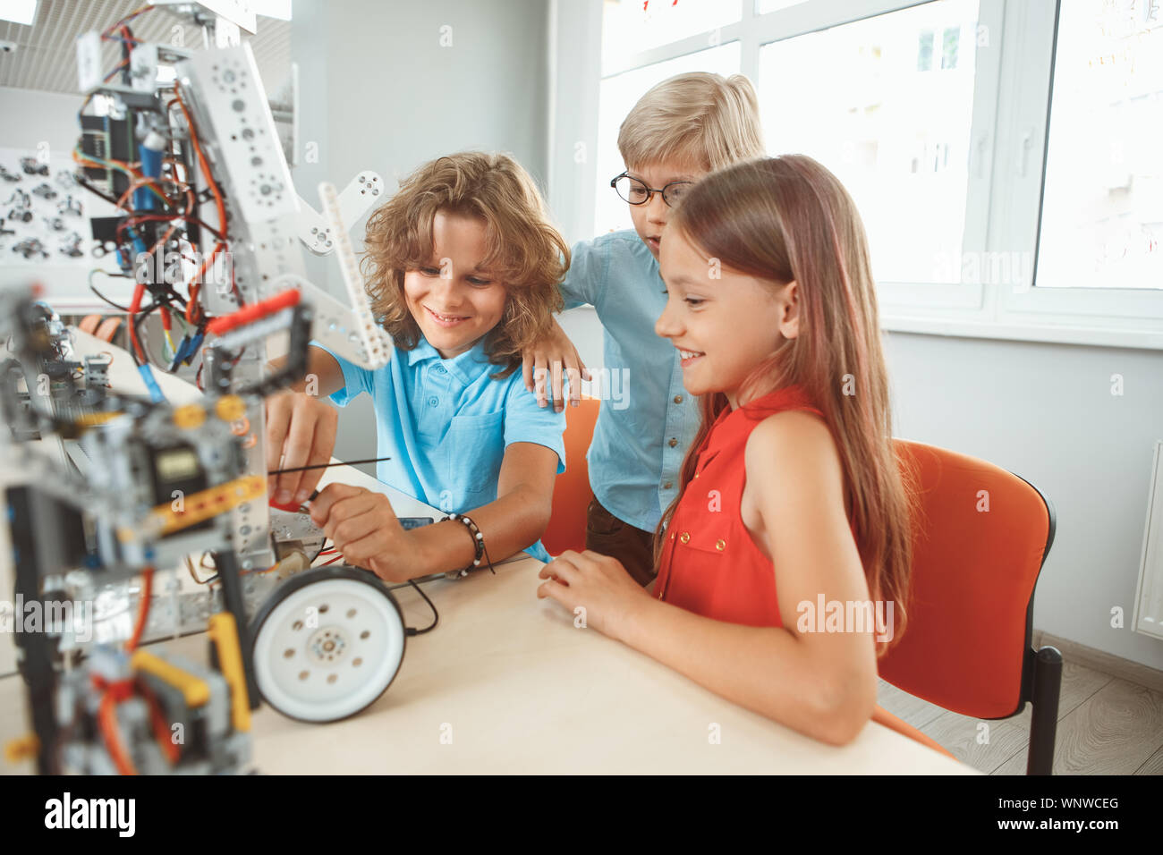 Robotik. Kinder sitzen in der Klasse und Roboter Lächeln aufgeregt ...