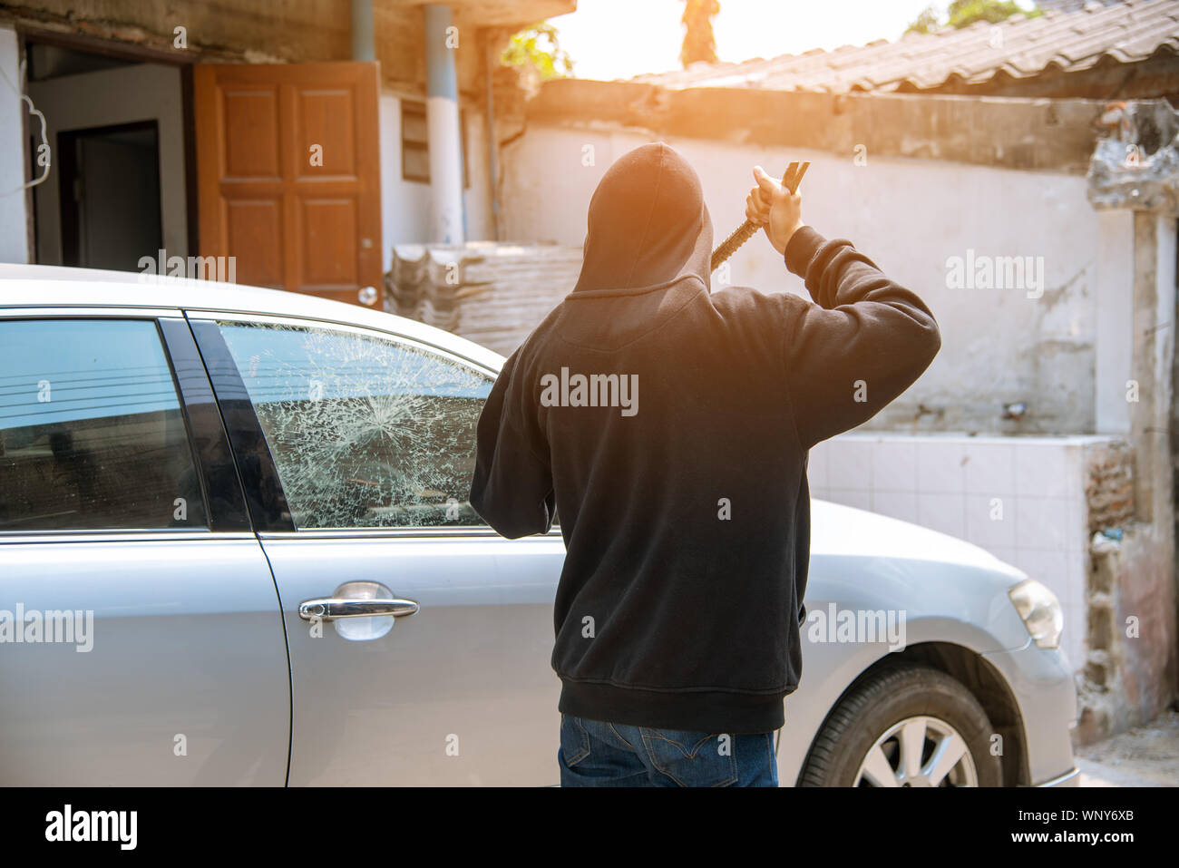 Auto Dieb Diebstahl Glas in ein Auto zu brechen. maskierte Gesicht Mann ...