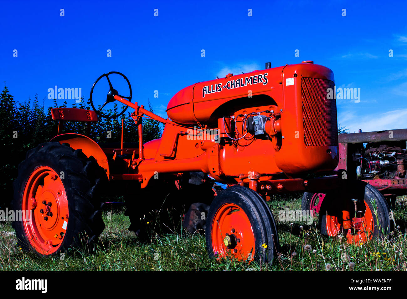 Leuchtend rote Traktor in der Morgensonne Stockfotografie - Alamy