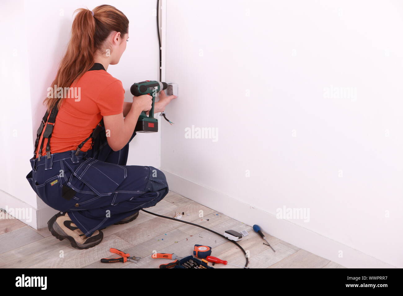 Frau loch bohren wand -Fotos und -Bildmaterial in hoher Auflösung – Alamy