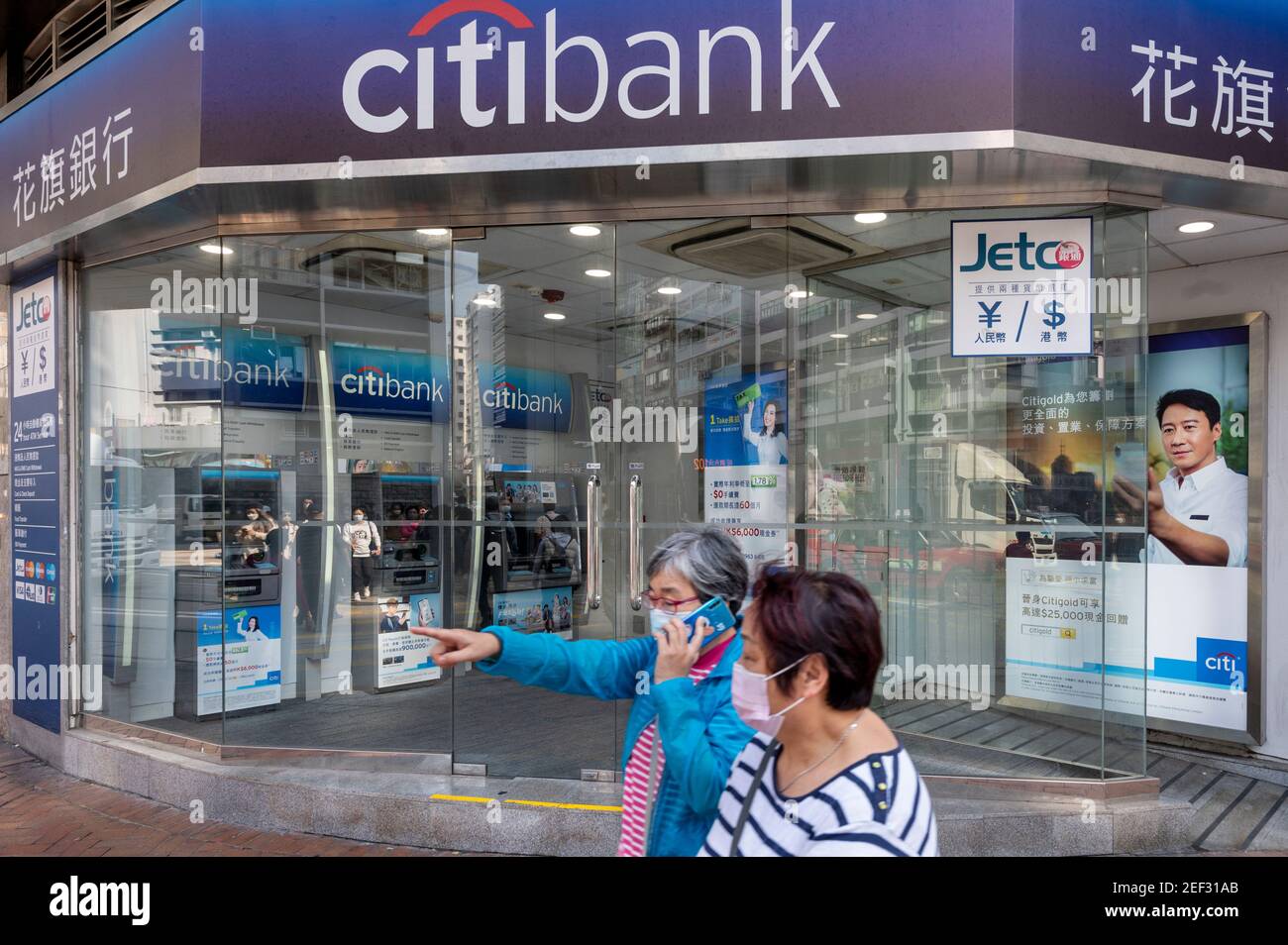 Los peatones que usan máscaras pasan por el banco de inversión multinacional estadounidense y la ...