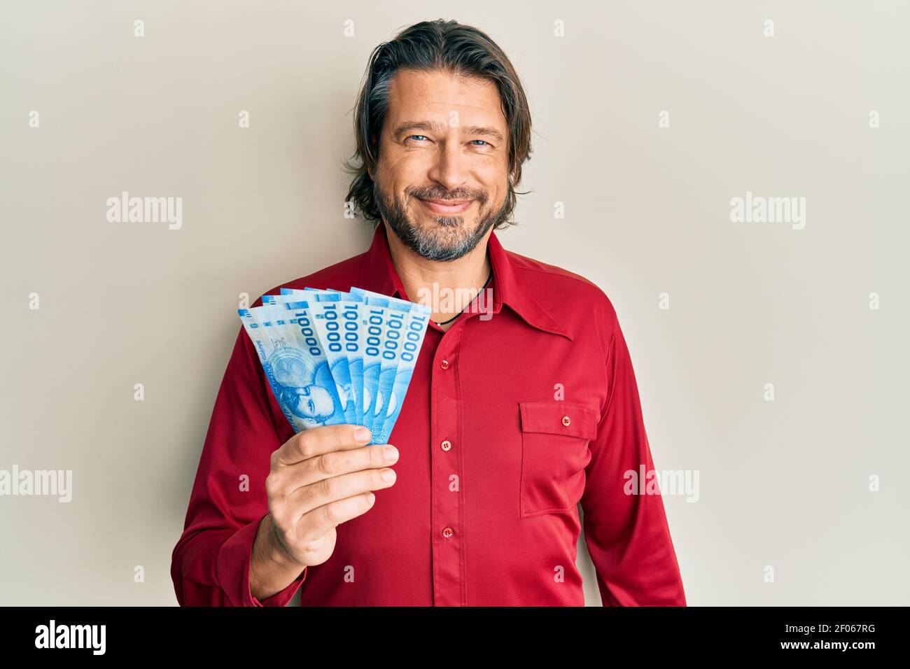 Hombre guapo de mediana edad con 10000 pesos chilenos que parece ...