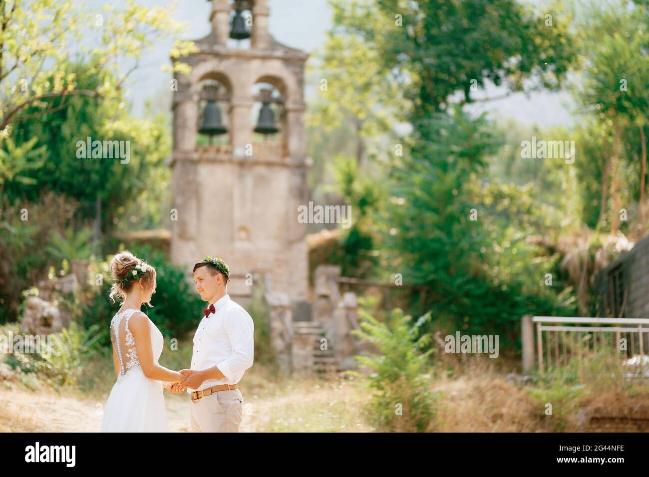 La Novia Y El Novio Mirando Uno Al Otro Y Sosteniendo Manos Y Beso En la-novia-y-el-novio-mirando-uno-al-otro-y-sosteniendo-manos-y-beso-en
