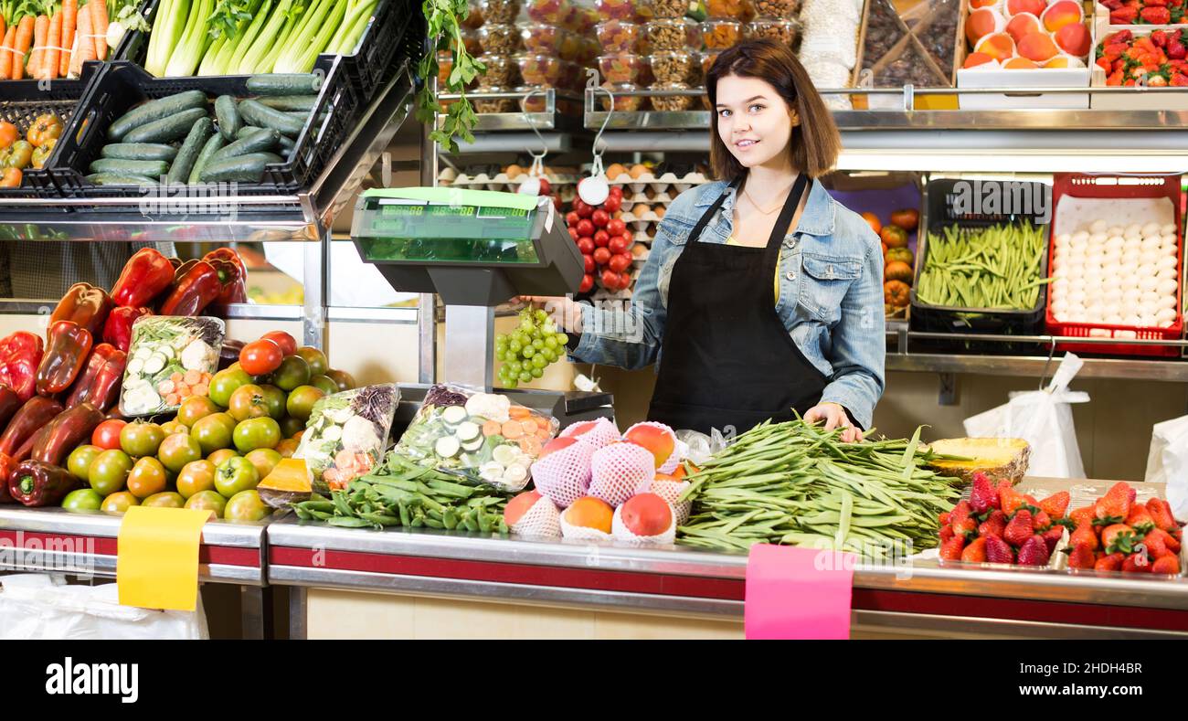 asistente de compras que pesa frutas y verduras en la tienda de ... asistente de compras que pesa frutas y verduras en la tienda de ...