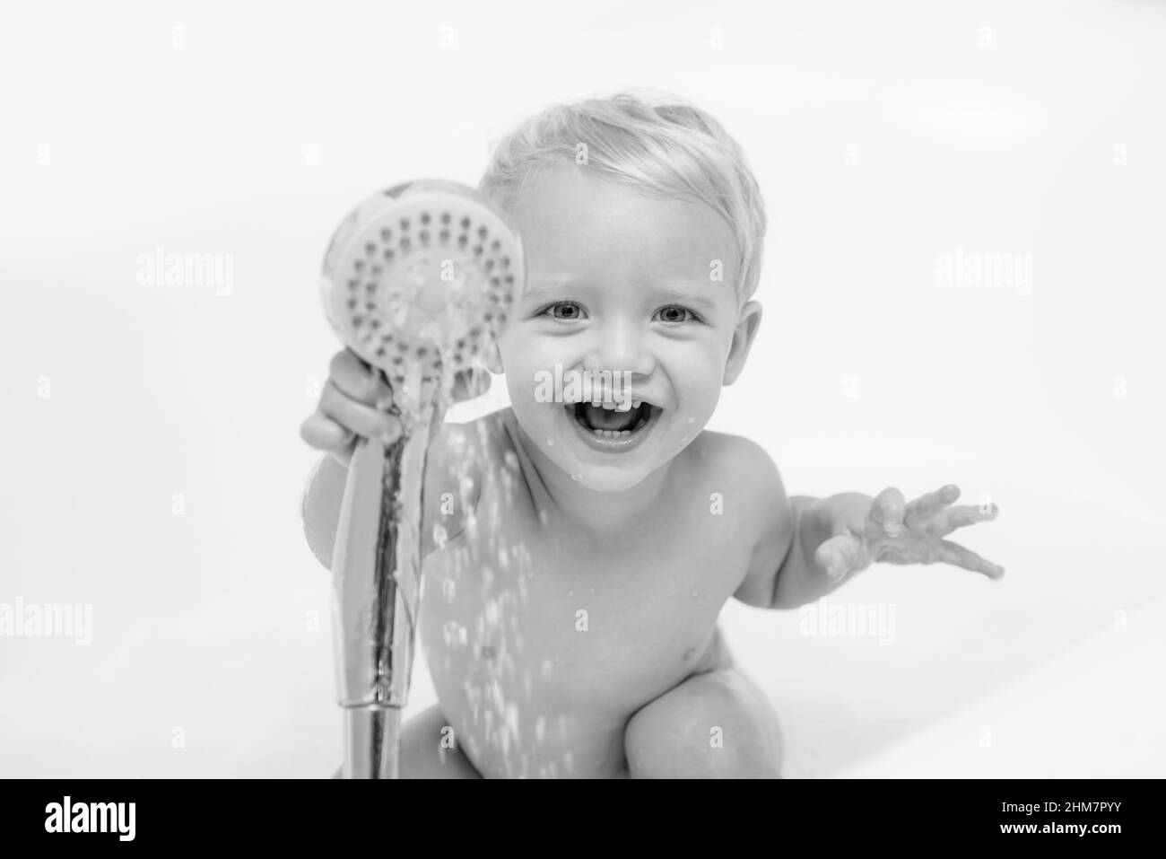Higiene de los niños. Un bebé divertido jugando con agua y espuma en un ... Higiene de los niños. Un bebé divertido jugando con agua y espuma en un ...