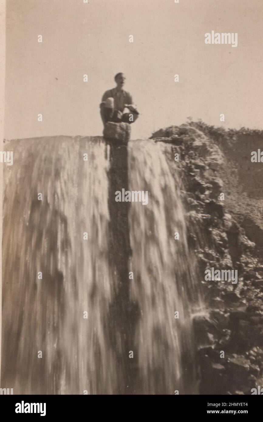 Hombre haciendo sentado en la cima de la cascada en el pasado (en los ...