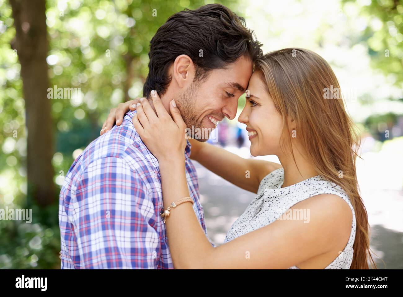 Romance en el parque. Una pareja joven feliz de pie de brazo en brazo ...