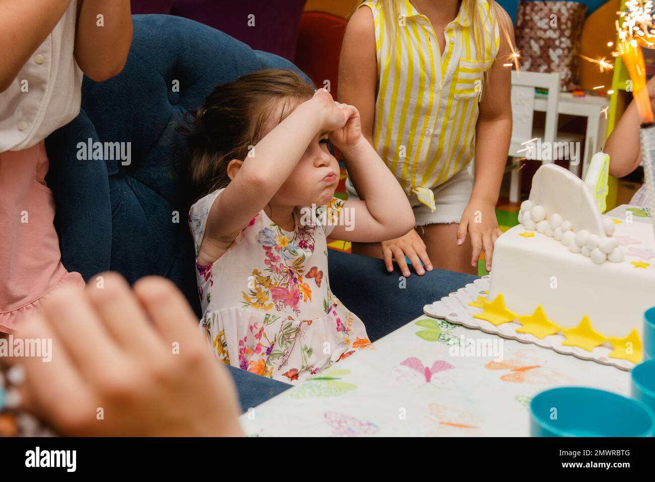 Niño en fiesta de cumpleaños soplando velas en pastel rodeado de amigos ... Niño en fiesta de cumpleaños soplando velas en pastel rodeado de amigos ...