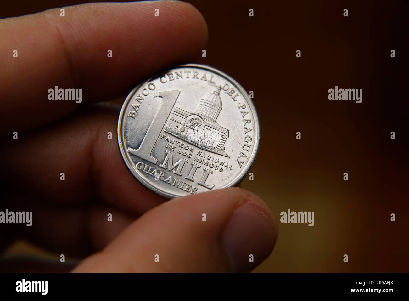 mil moneda guaraní de paraguay entre dedos - guaranies de moneda ...