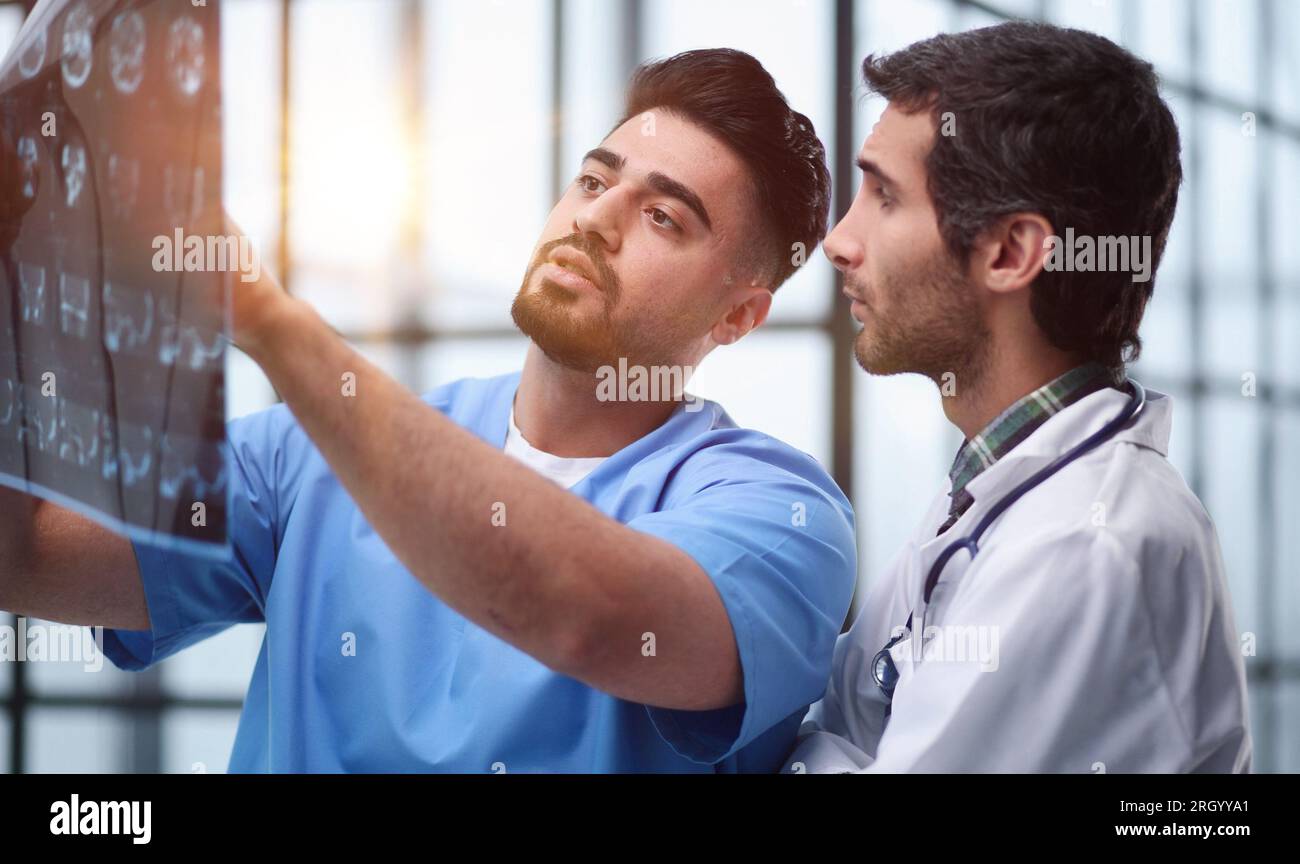 Los Médicos Y Un Interno Examinan Una Radiografía De Un Paciente