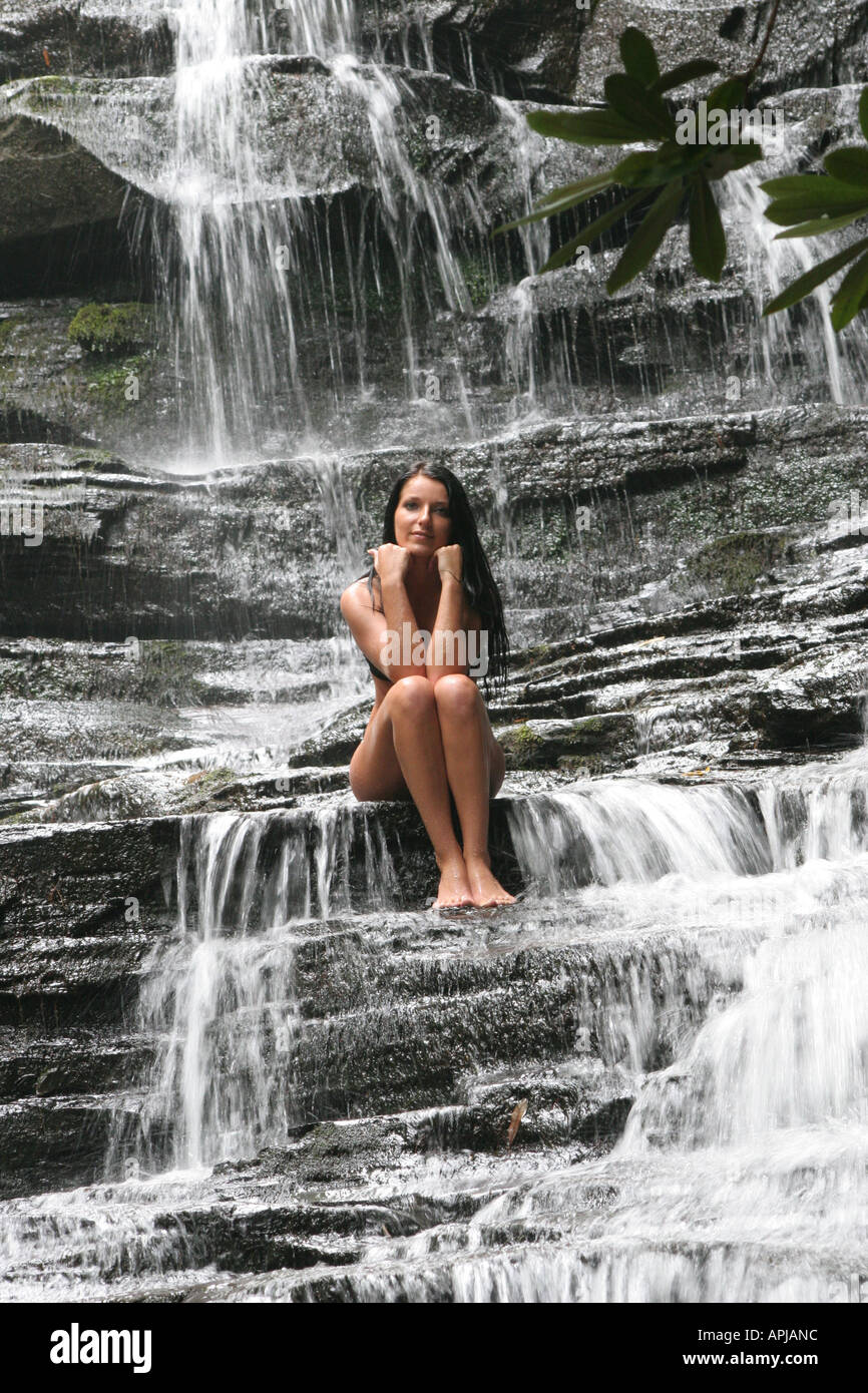 Mujer En Bikini Sentada En Medio De Una Cascada Con Sus Codos Sobre Sus