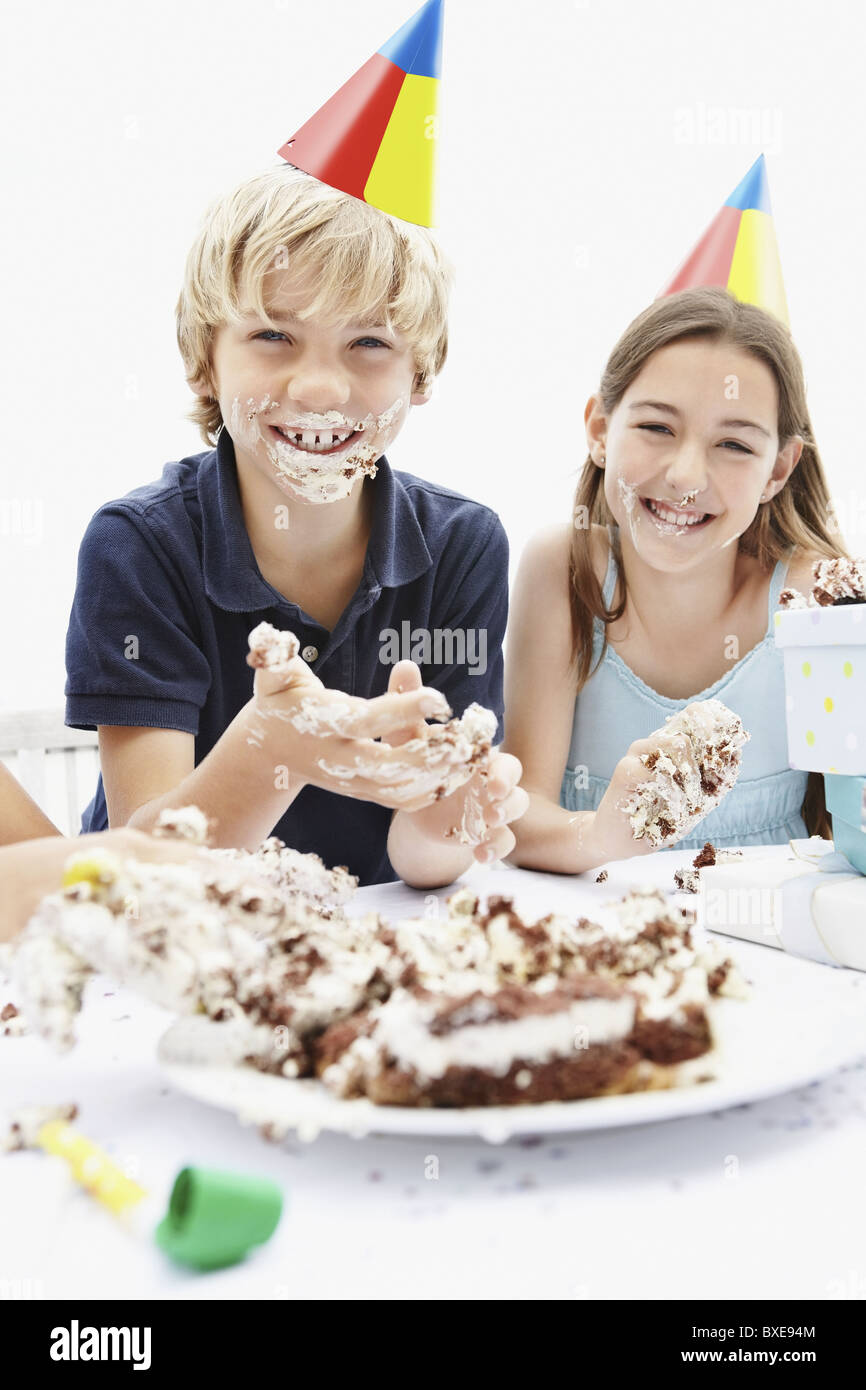 Los Niños Comiendo Pastel De Cumpleaños Con Sus Manos Fotografía De