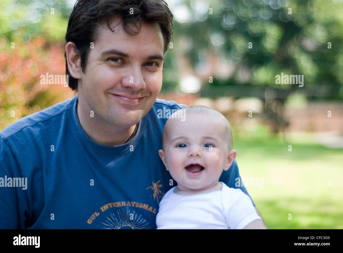 Una mujer vestida con un bebé babygrow blanco, sentada en el regazo de ...