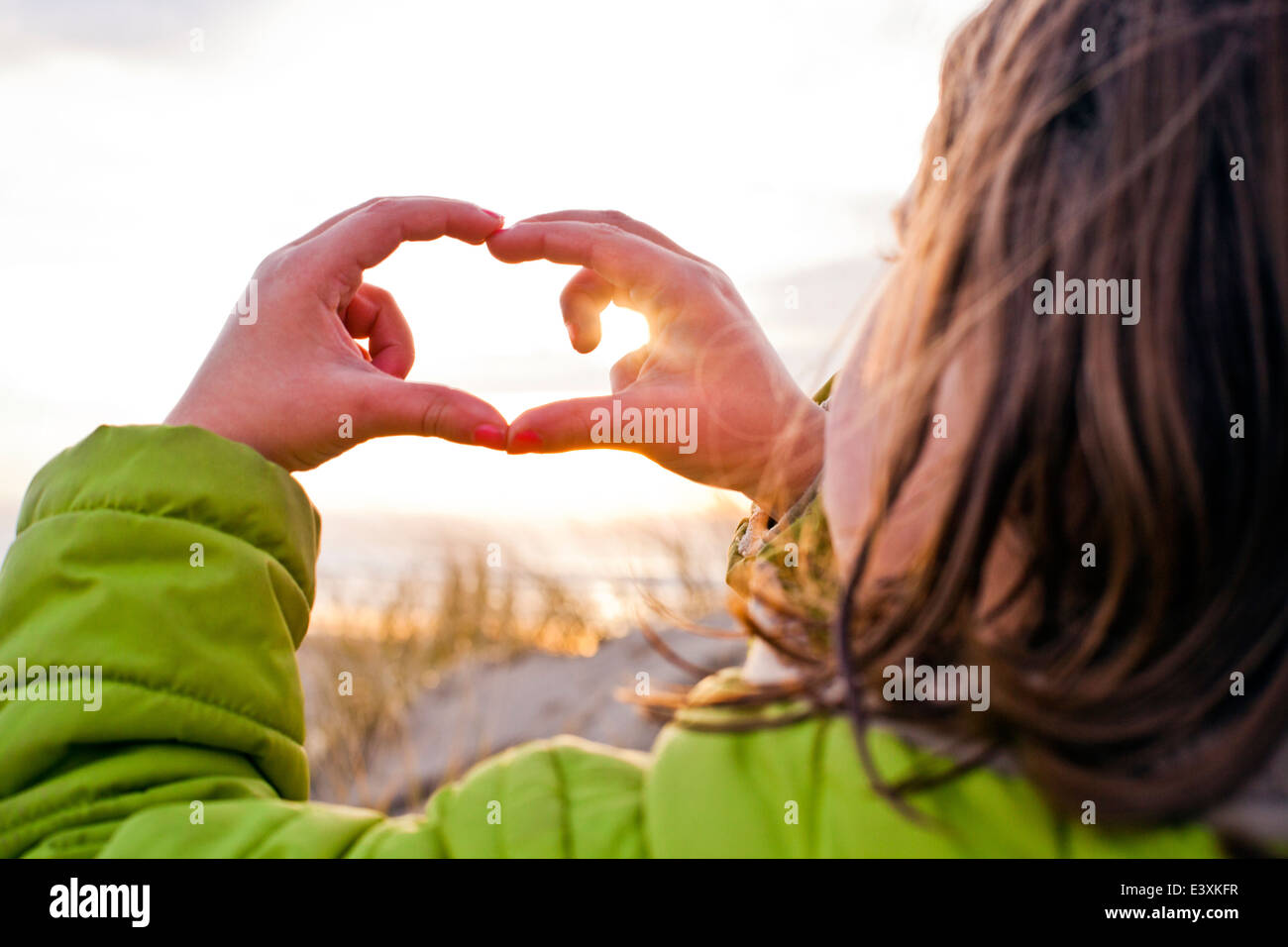 Chica Caucásica Admirando Sunset A Través De Manos Fotografía De Stock