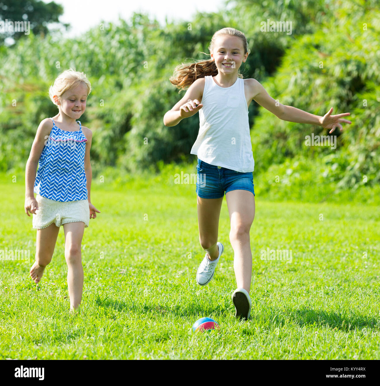 Dos Pequeñas Niñas Feliz Jugando Con La Bola Al Aire Libre Correr