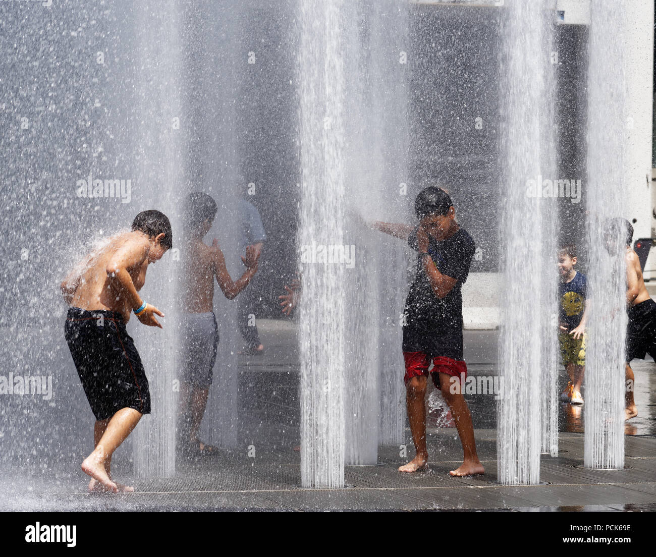 Los niños refrescarse jugando en fuentes de agua en Rue Jeanne Mance en ...