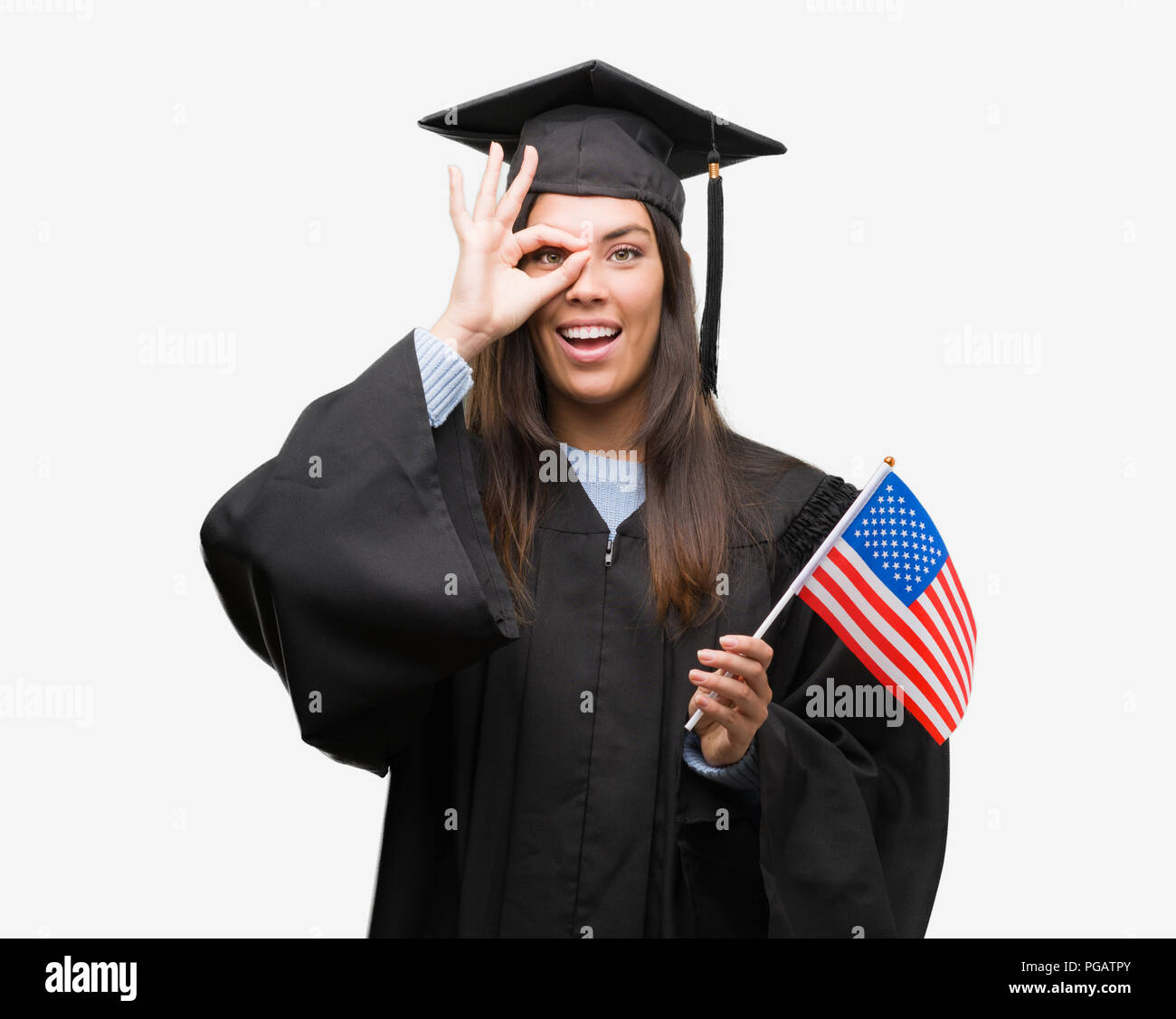 Joven hispana vistiendo uniforme graduada sosteniendo la bandera de ...