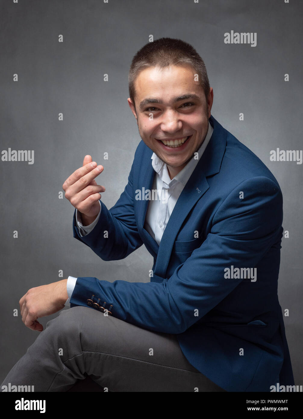 Guapo exitoso empresario de traje azul sentado y mostrar las ... Guapo exitoso empresario de traje azul sentado y mostrar las ...