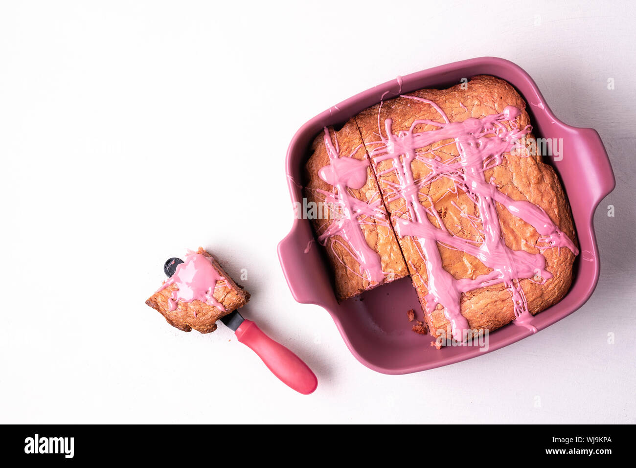 Rosa pastel brownie en la bandeja y en una parte en blanco de la tabla ...