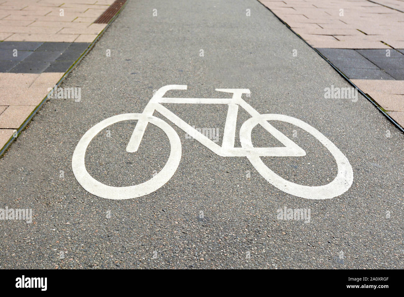 Piste cyclable avec pictogramme vélo blanc peint sur la masse sur la ...