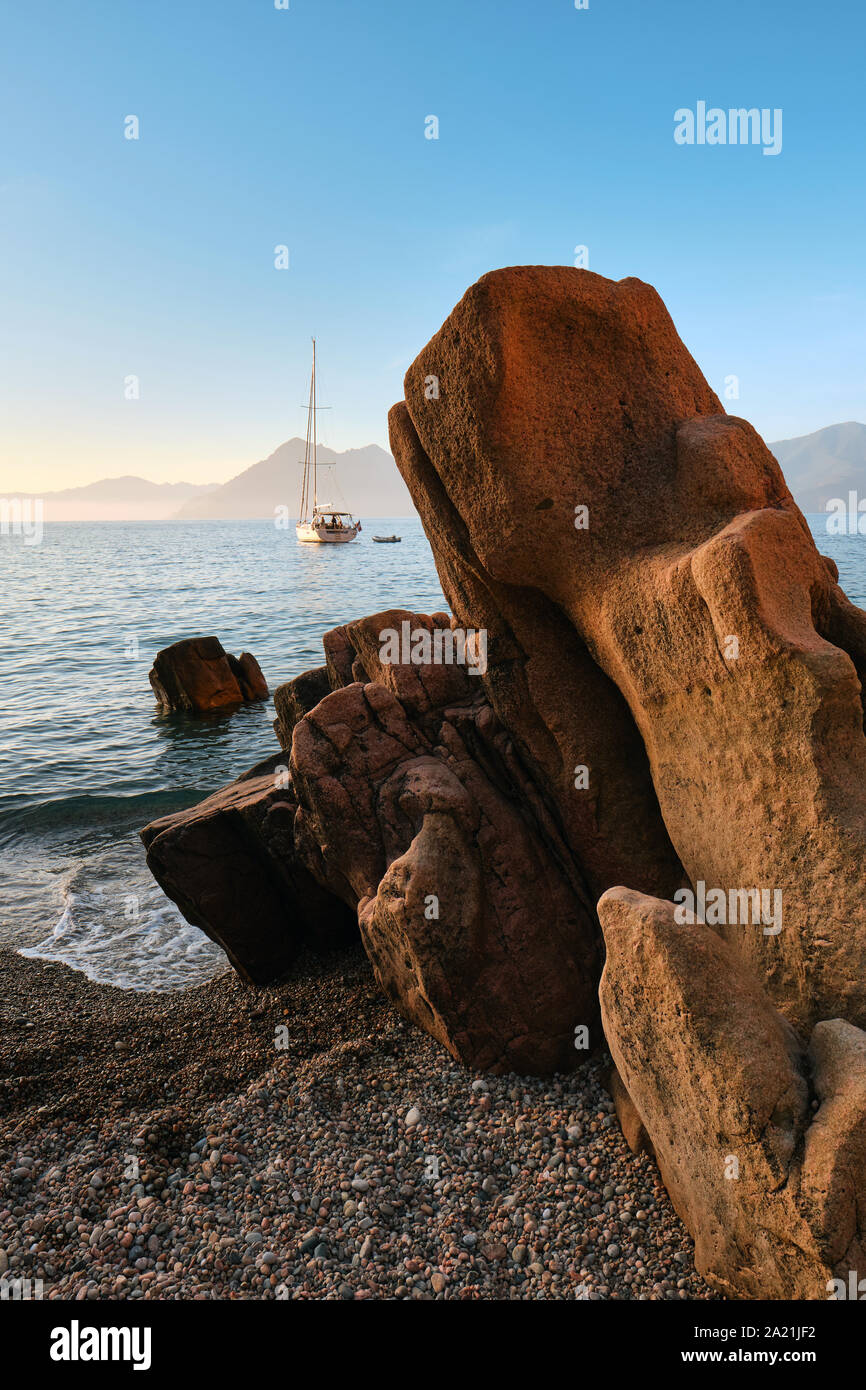 Un yacht, des formations de roche de granit rouge et la plage d'Plage ...