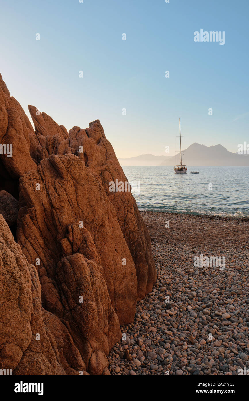 Un yacht, des formations de roche de granit rouge et la plage d'Plage ...