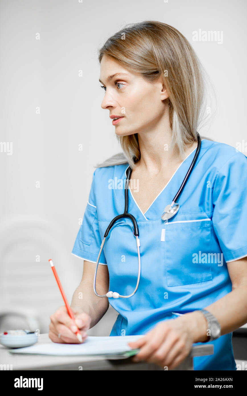 Portrait d'une belle infirmière en uniforme bleu avec écrit stéthoscope ...