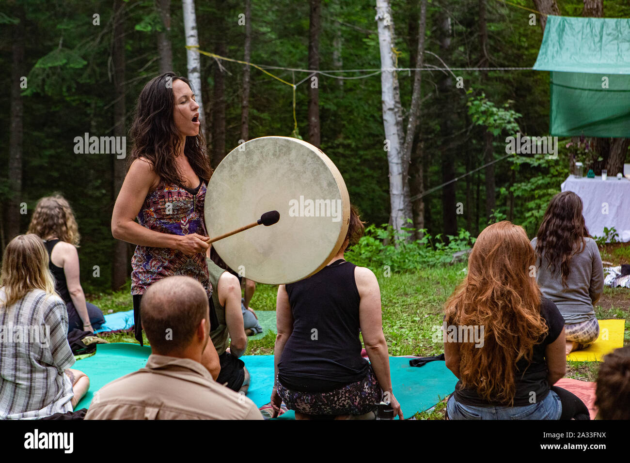 Une jeune femme chaman est vu jouer un tambour traditionnels ...