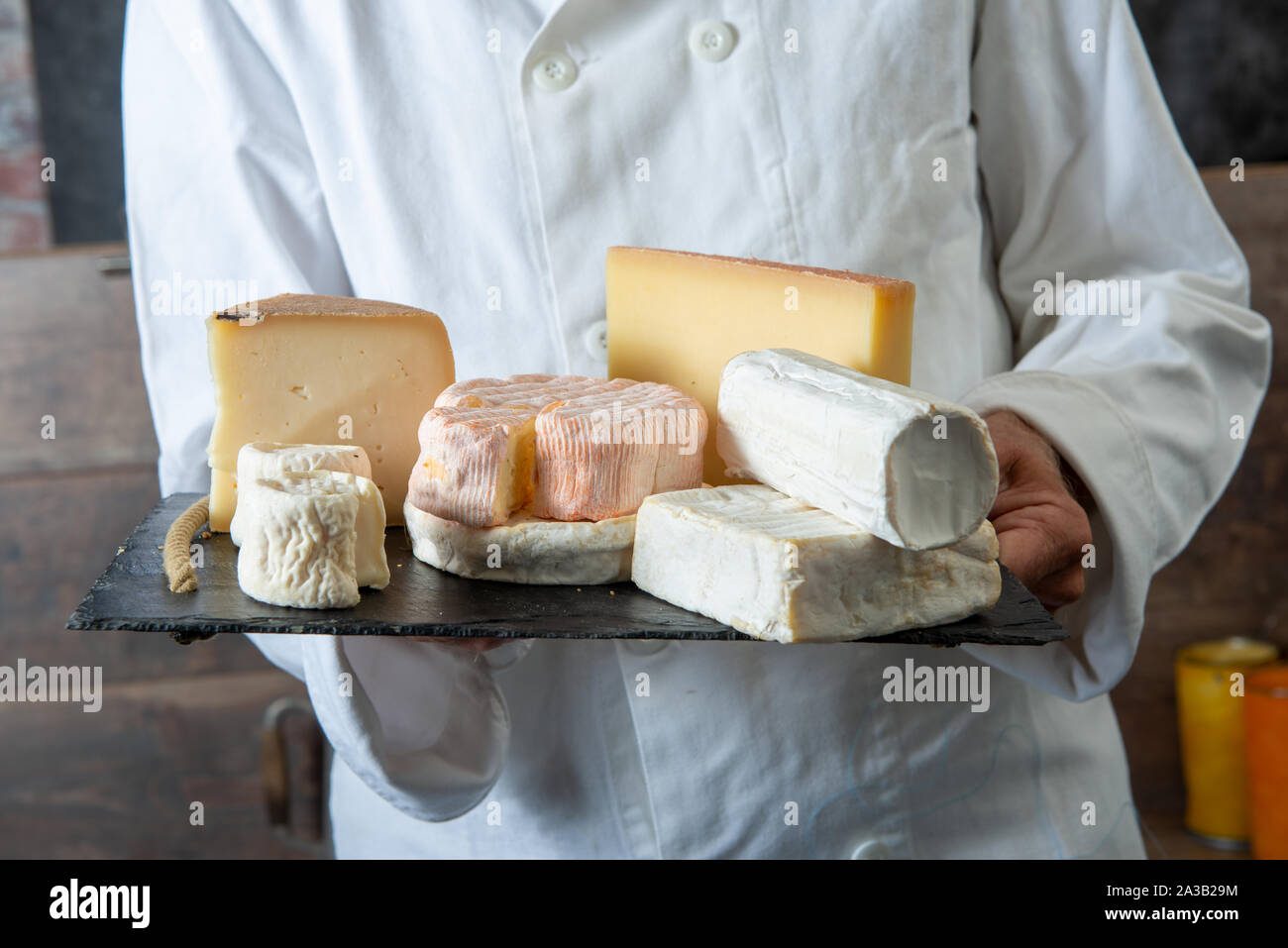 Homme tenant un plateau avec les différents fromages français Photo ...