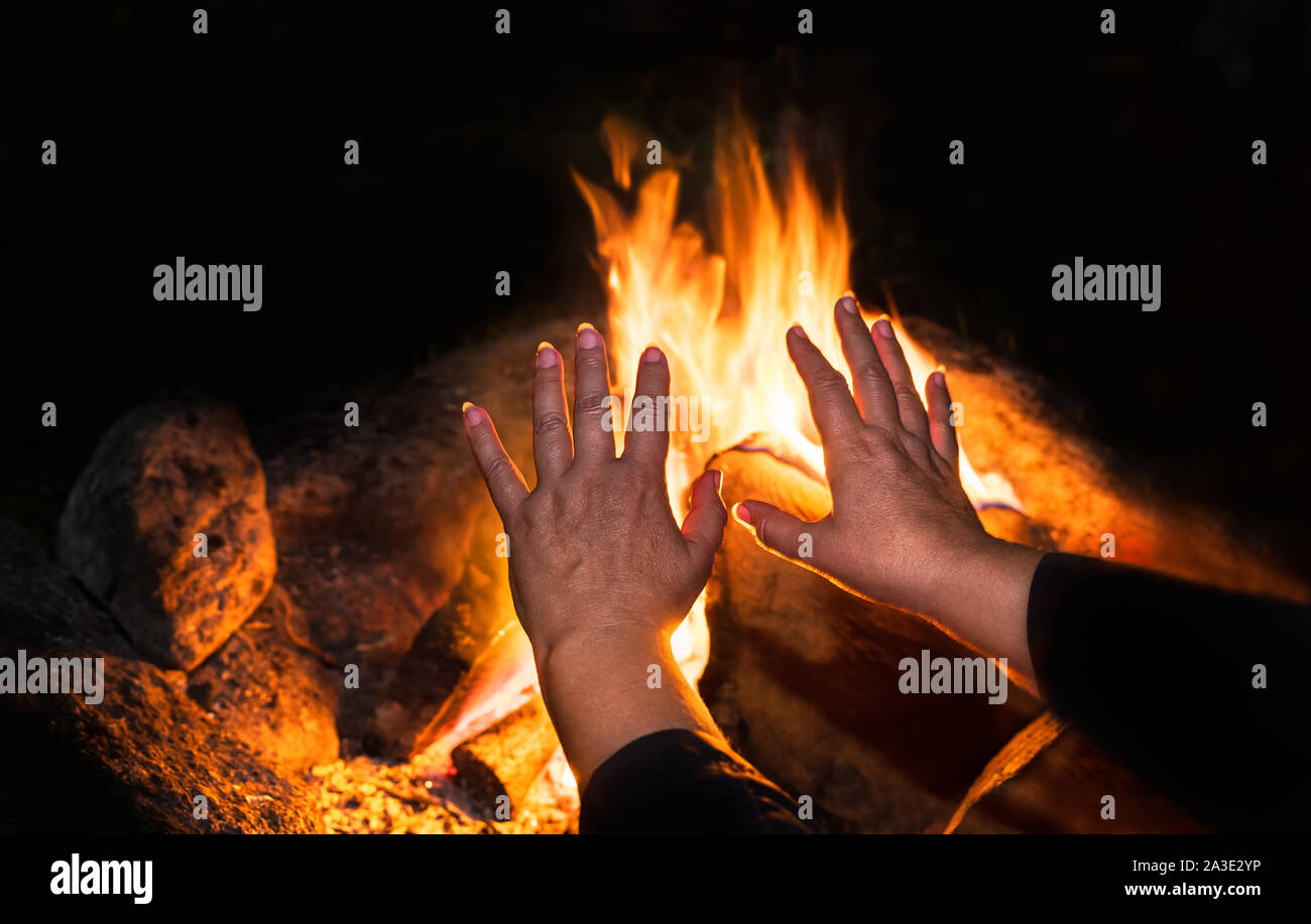 Feu Ardent et vieille femme solitaire en détail sur fond noir de nuit ...