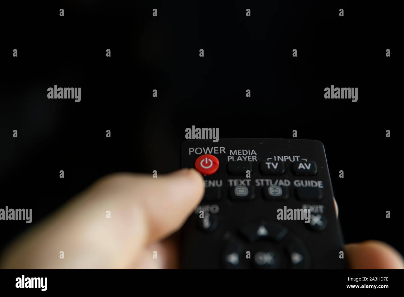 Gros plan sur la main d'un homme avec la télécommande veulent mettre le ...