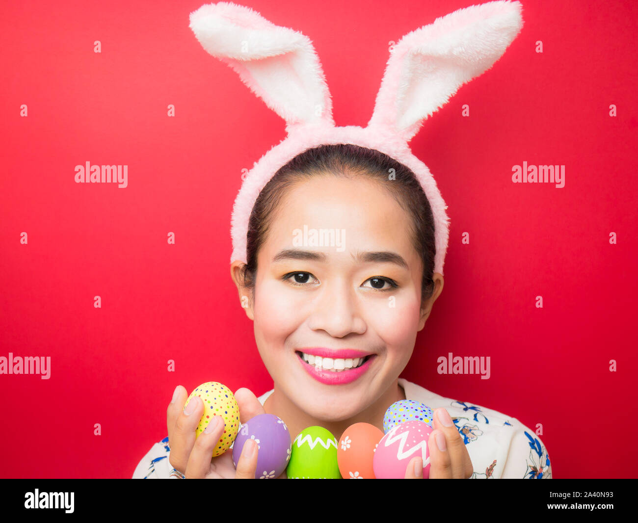 Woman wearing Bunny Ears headband et transportant des oeufs de Pâques ...