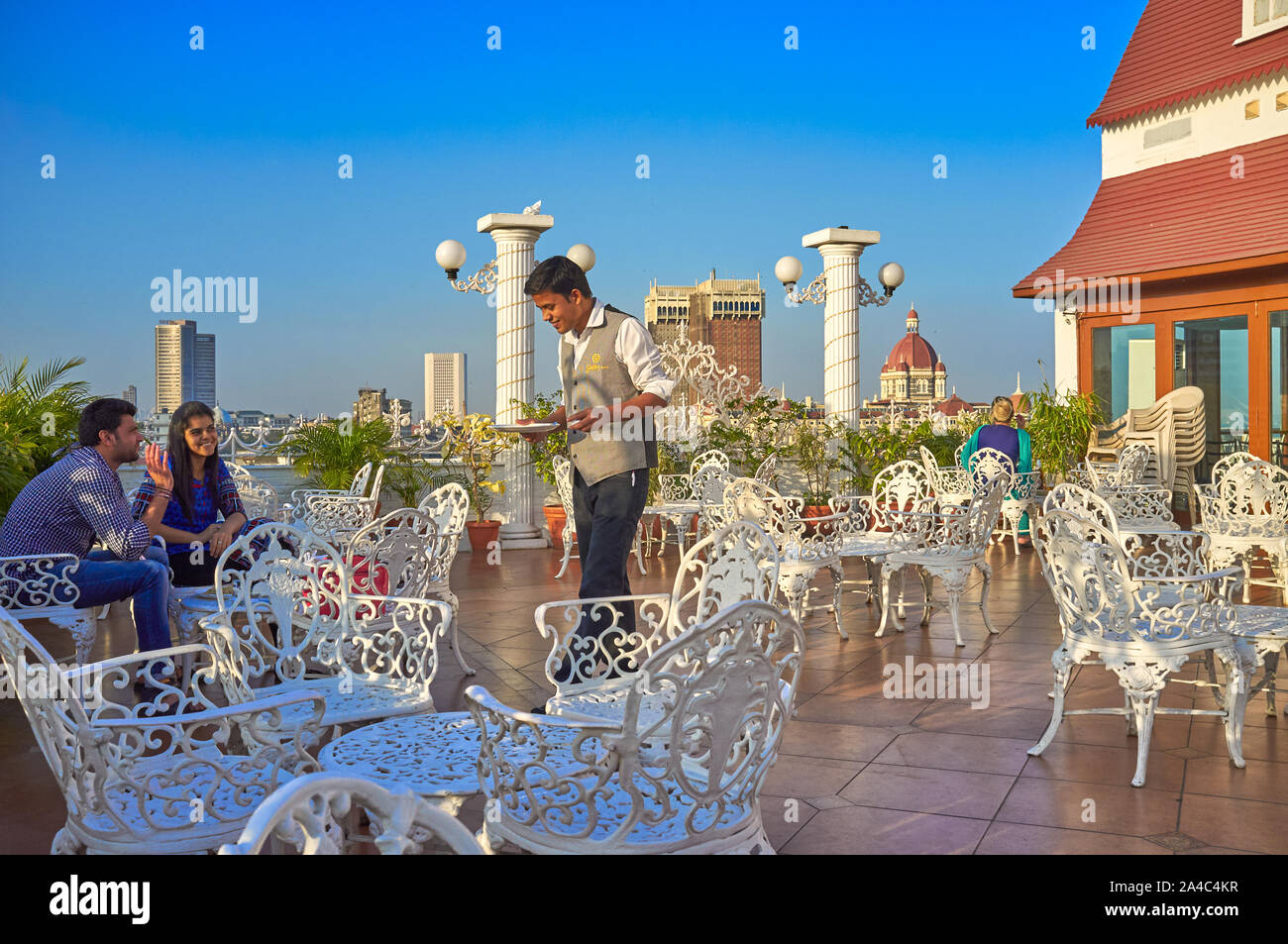 Un serveur sert les clients dans le toit terrasse du restaurant de l ...
