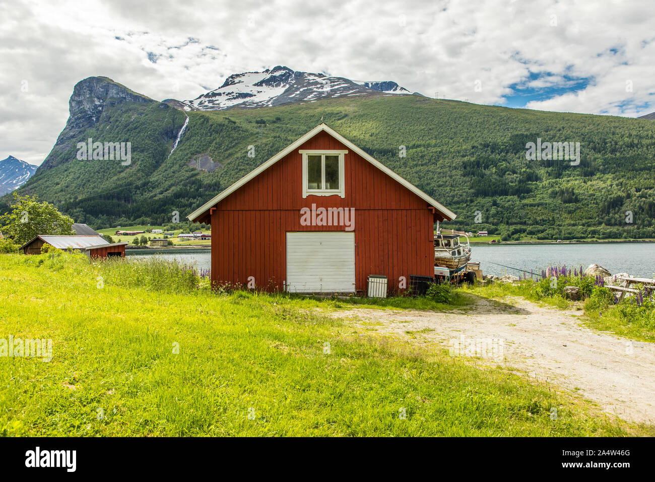 Maison en bois rouge traditionnelle norvégienne avec une cascade au ...