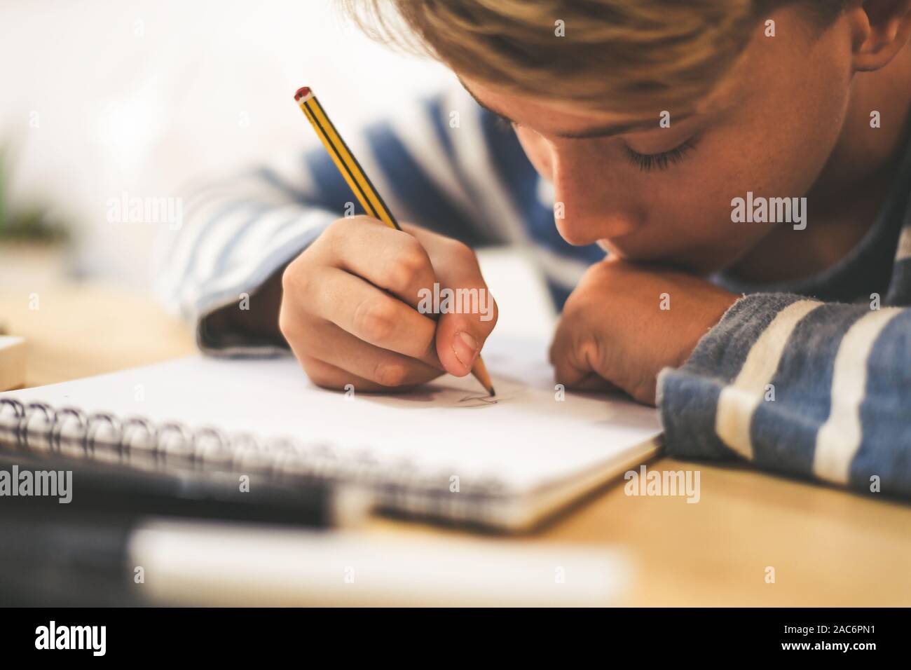 Dessin au crayon d'étudiants sur l'ordinateur portable. Boy doing ...