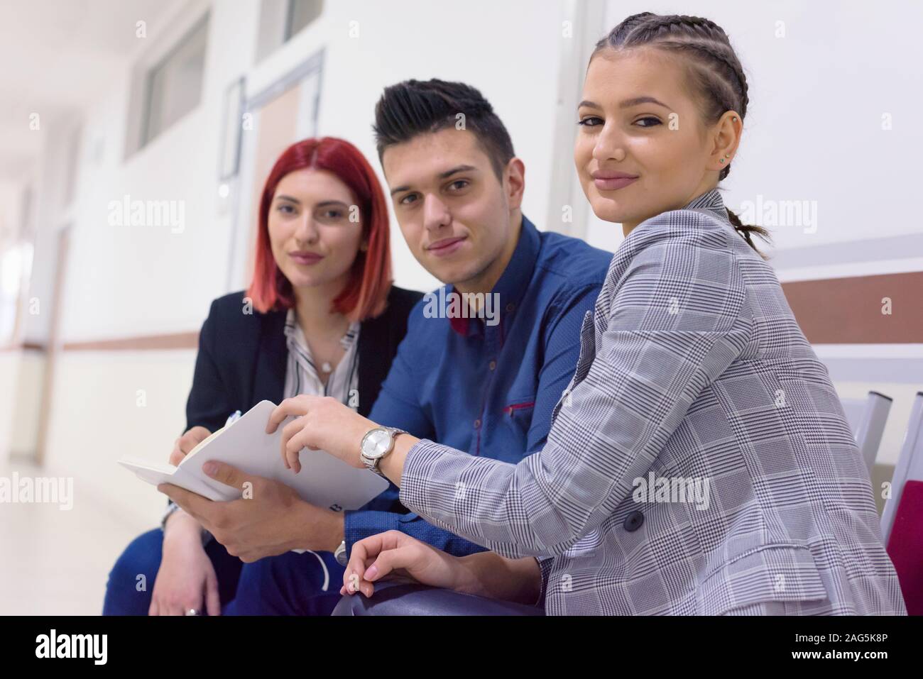 Trois étudiants du collège s'entretenir après leur classe. Groupe d ...