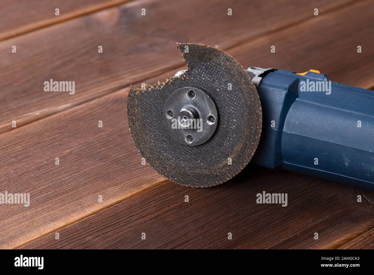 Une meuleuse avec une lame cassée sur une table en bois. Le danger d ...