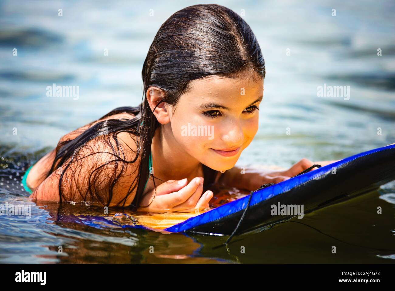 Jeune Fille Dans Un Maillot De Bain Sur Un Kickboard Au Lac Photo Stock