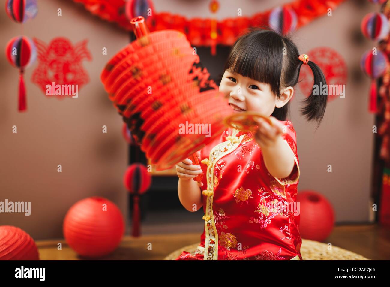 Bébé fille chinoise traditionnelle avec dressing up main courante avec ...