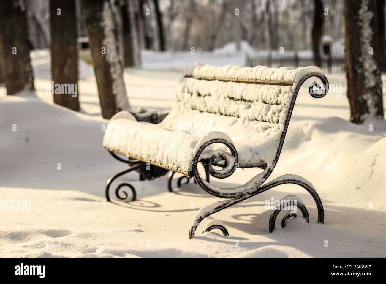 Le banc est recouvert de neige et de glace sur un jour d'hiver ...